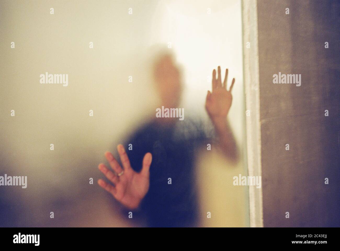 Man behind glass pane Stock Photo - Alamy