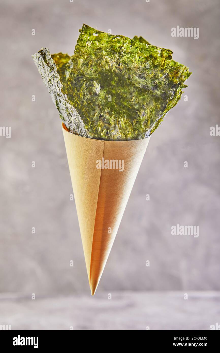 Crispy nori seaweed in a cone cup on a gray background. Japanese food ...