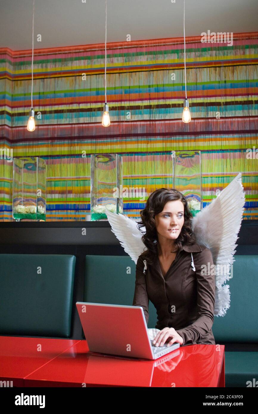 Woman with angel wings uses laptop, Berlin, Germany Stock Photo - Alamy