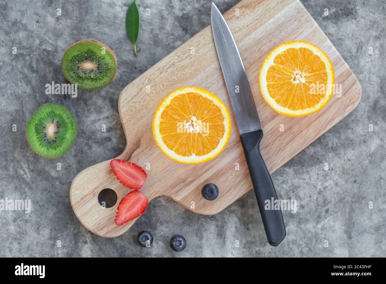 Cutting of mixed fruit, orange strawberry and kiwi fruit with cutting ...