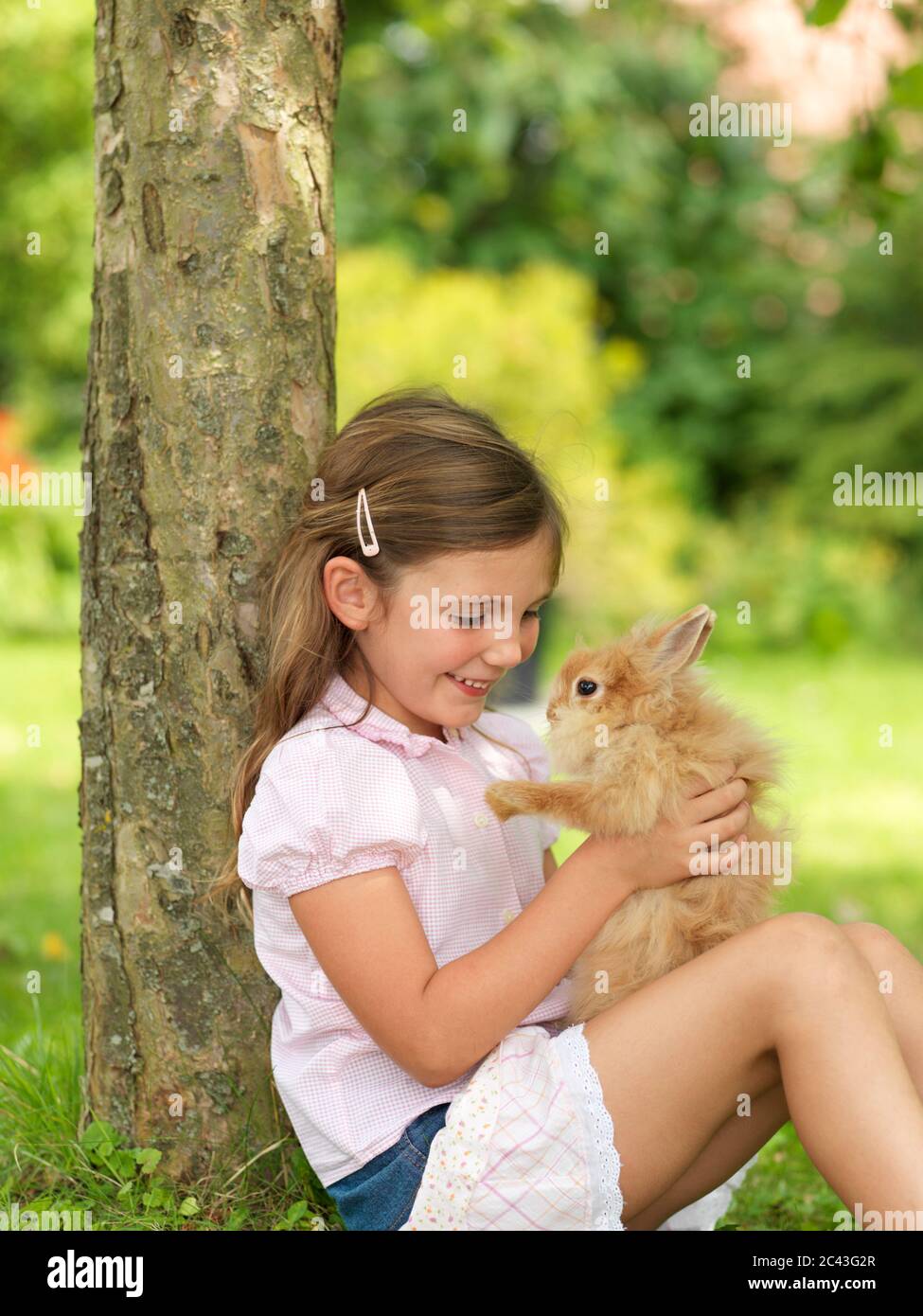 Girl with a rabbit in the garden, Munich, Bavaria, Germany Stock Photo ...