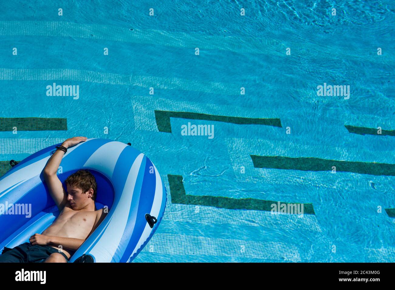 Boy in an inflatable boat in the swimming pool, French Riviera, France ...