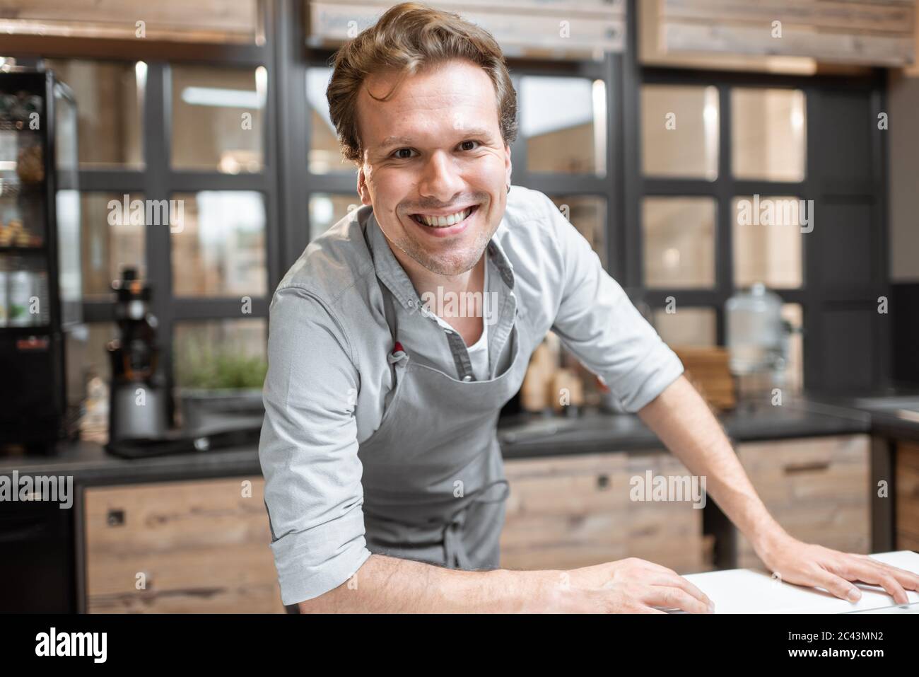 Cashier smiling behind counter hi-res stock photography and images - Alamy