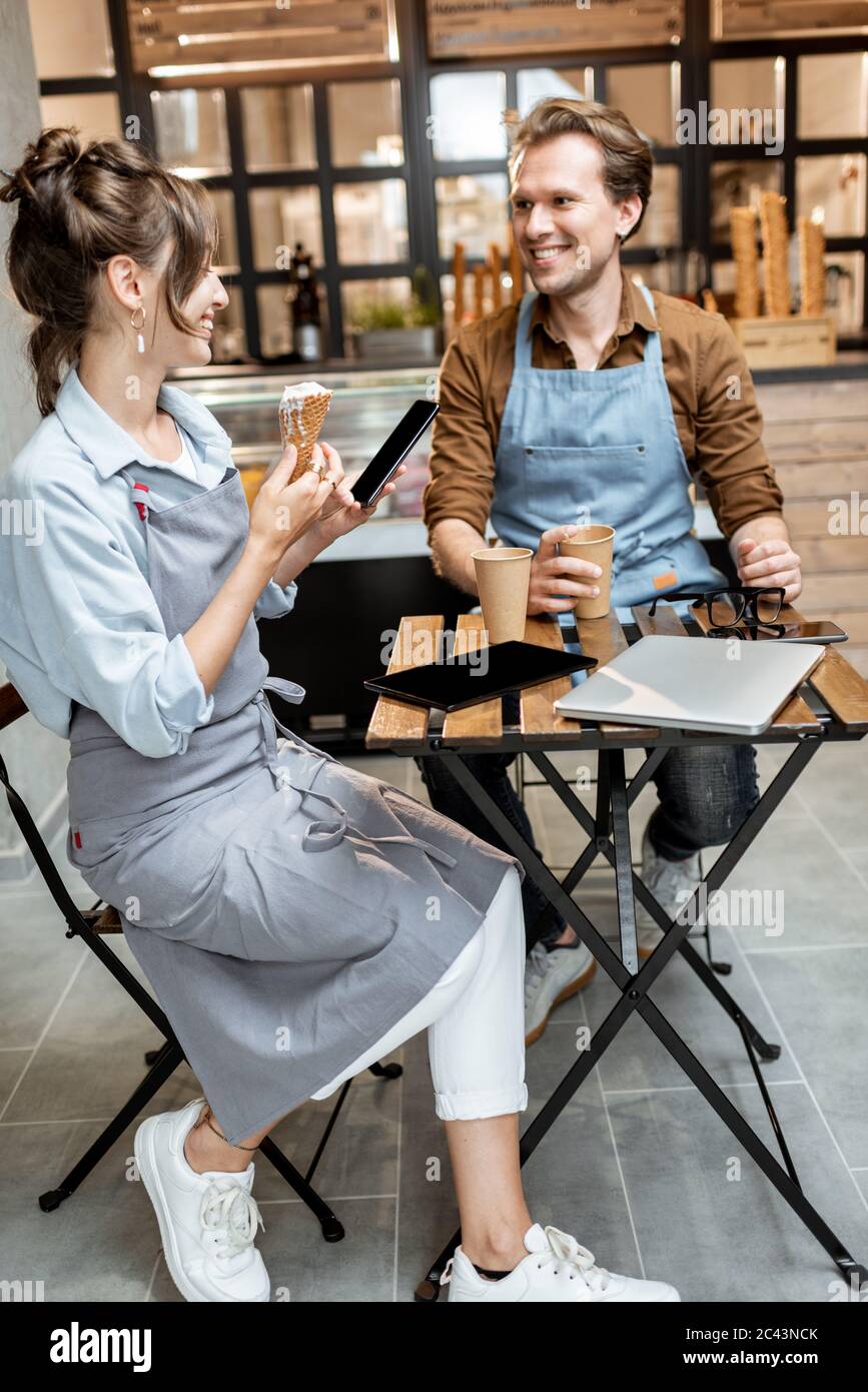 Couple of a young cafe workers have some business conversation while ...