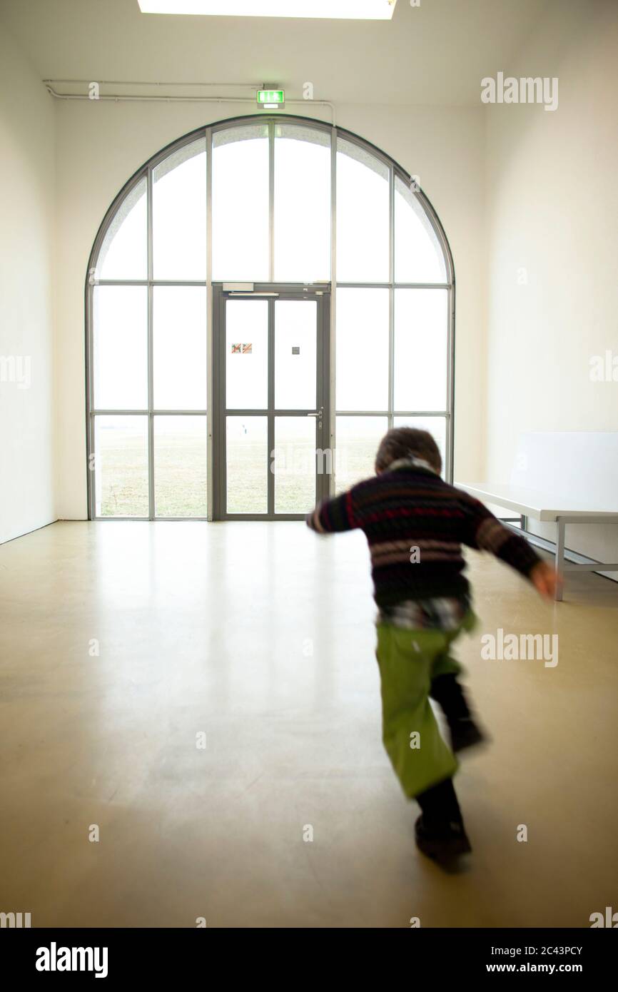 Boy runs down a hall Stock Photo - Alamy