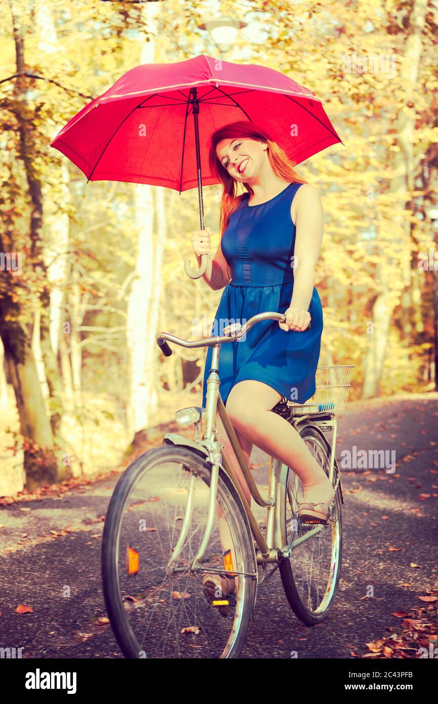 Nature, people, outdoors concept. Ginger hair girl is holding red ...