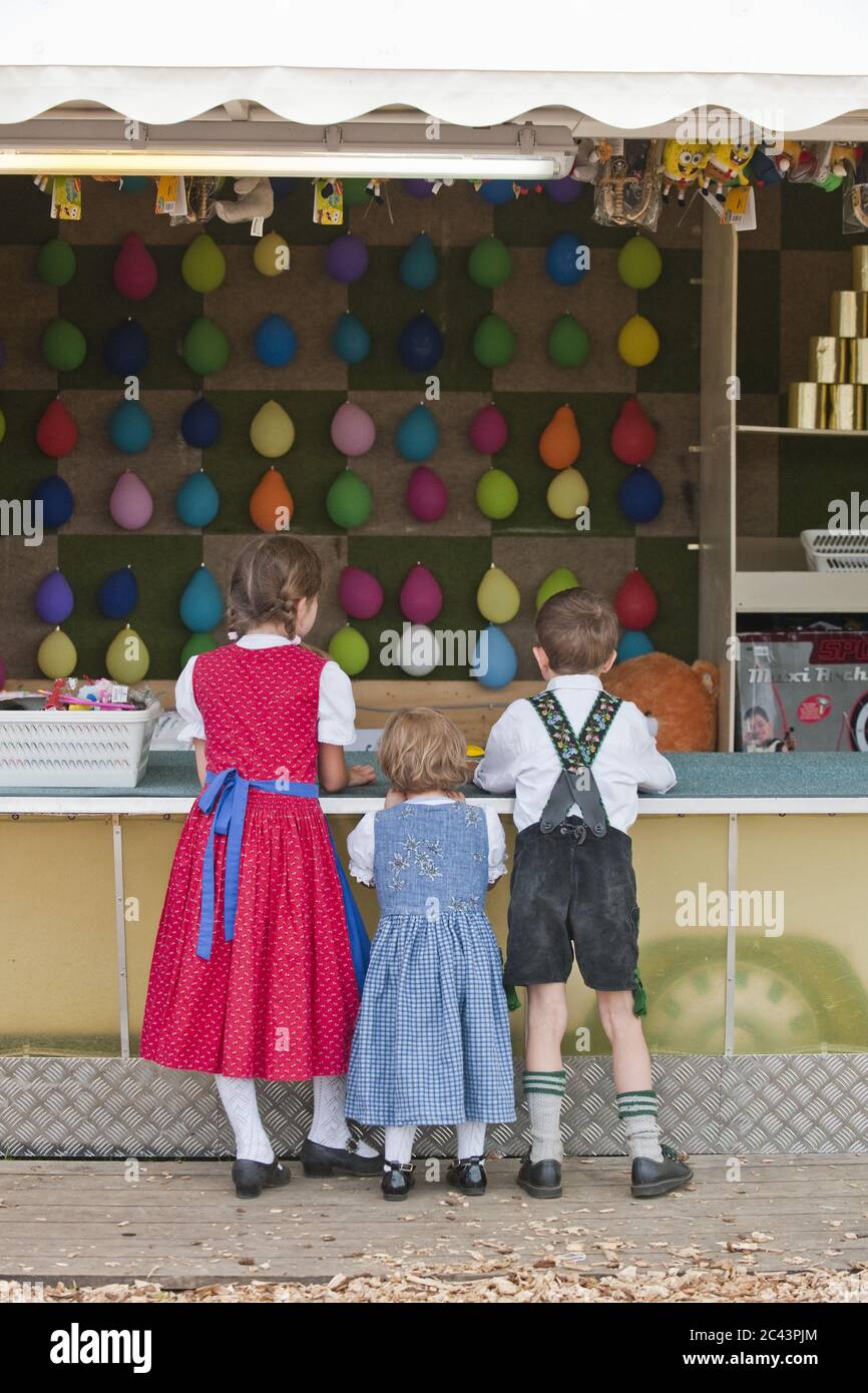 Three children stand at a fair stall Stock Photo - Alamy