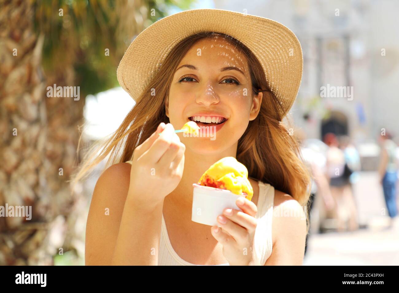 Close up of pretty tourist girl eating traditional gelato italian ice ...