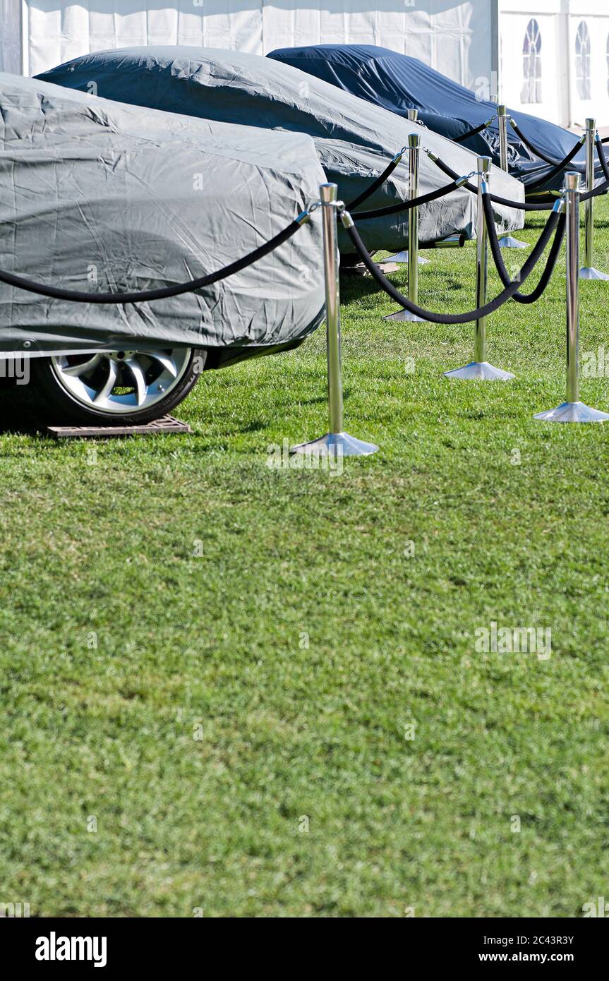 Shrouded cars behind a rope barrier at a car show, Stuttgart, Germany ...