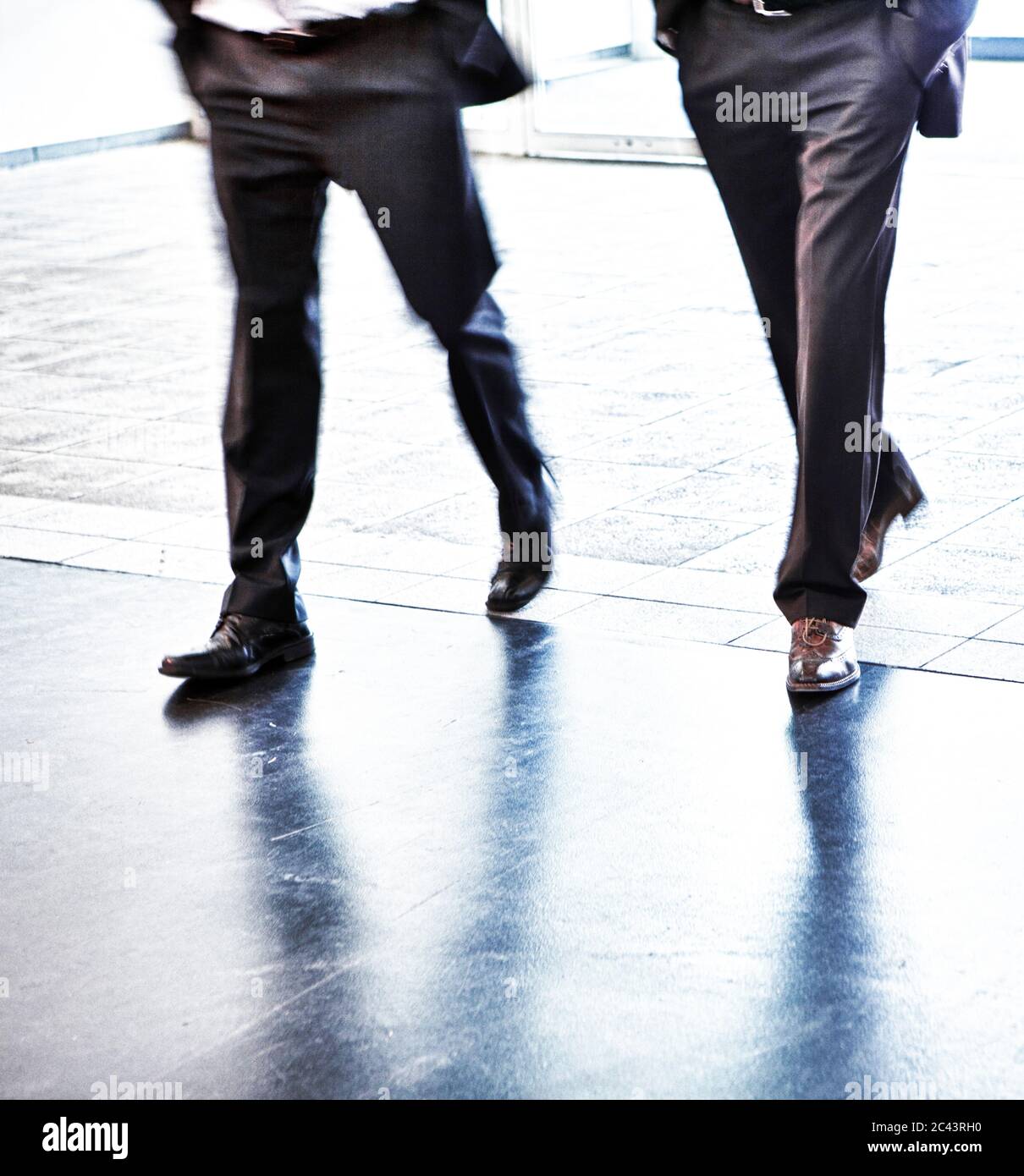 Two businessmen walk side by side Stock Photo - Alamy