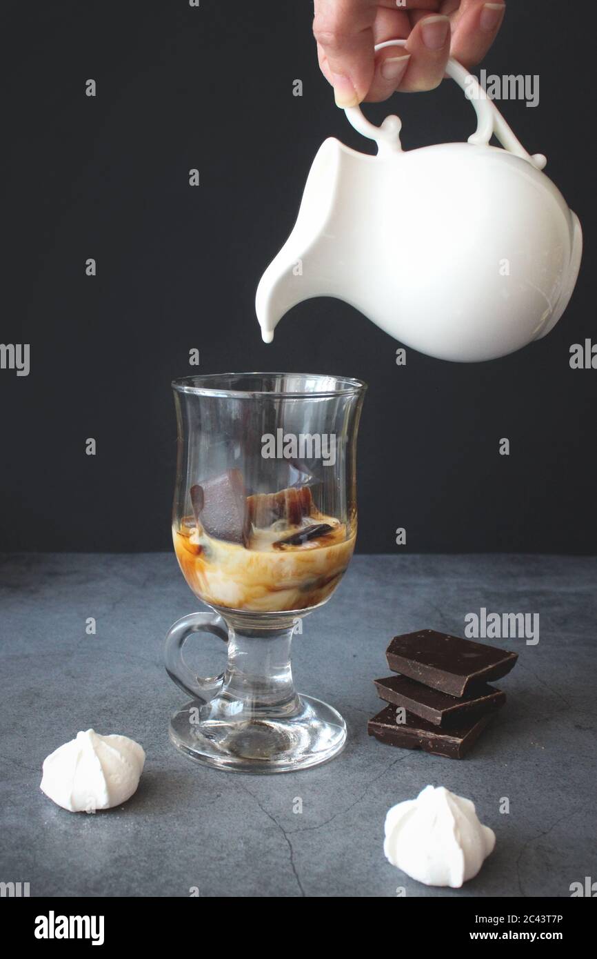 Pouring milk in ice coffee Stock Photo - Alamy