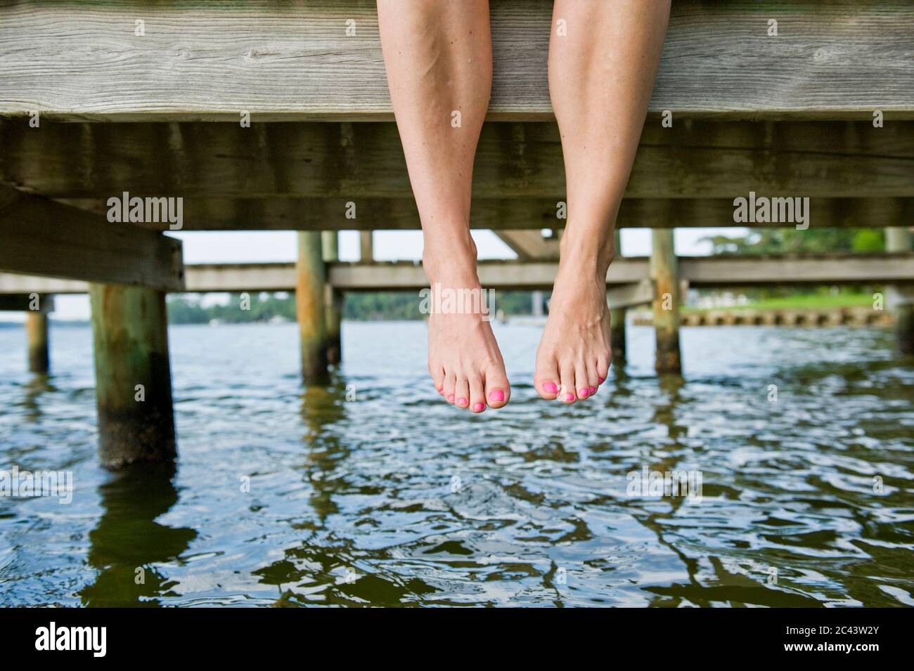 A woman's feet on a jetty above the water Stock Photo - Alamy