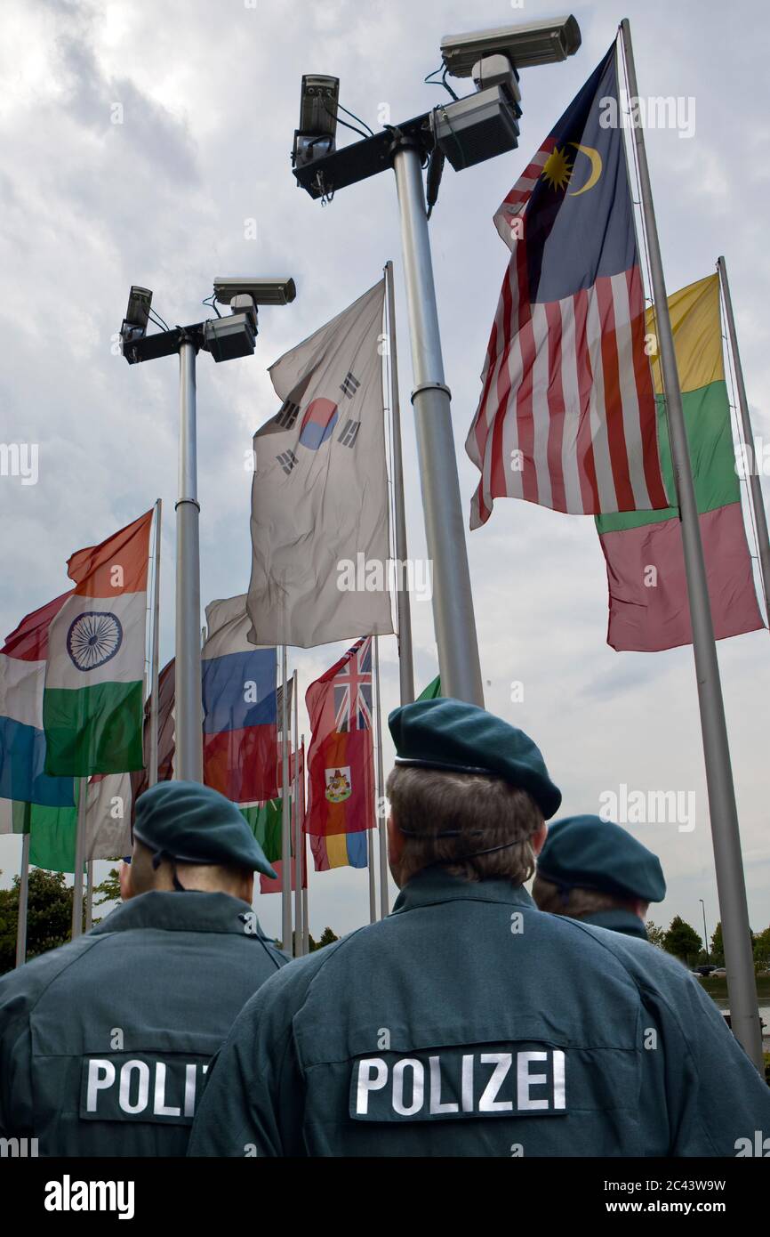 Police officers under various national flags and surveillance cameras ...
