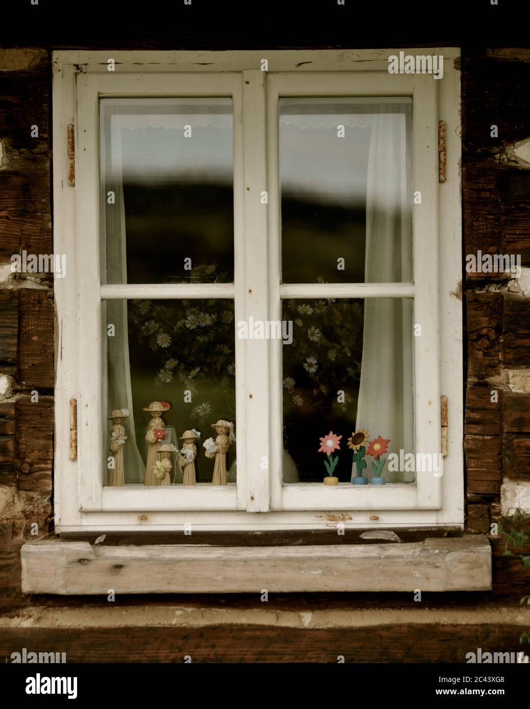Small figures and flowers behind a window Stock Photo - Alamy