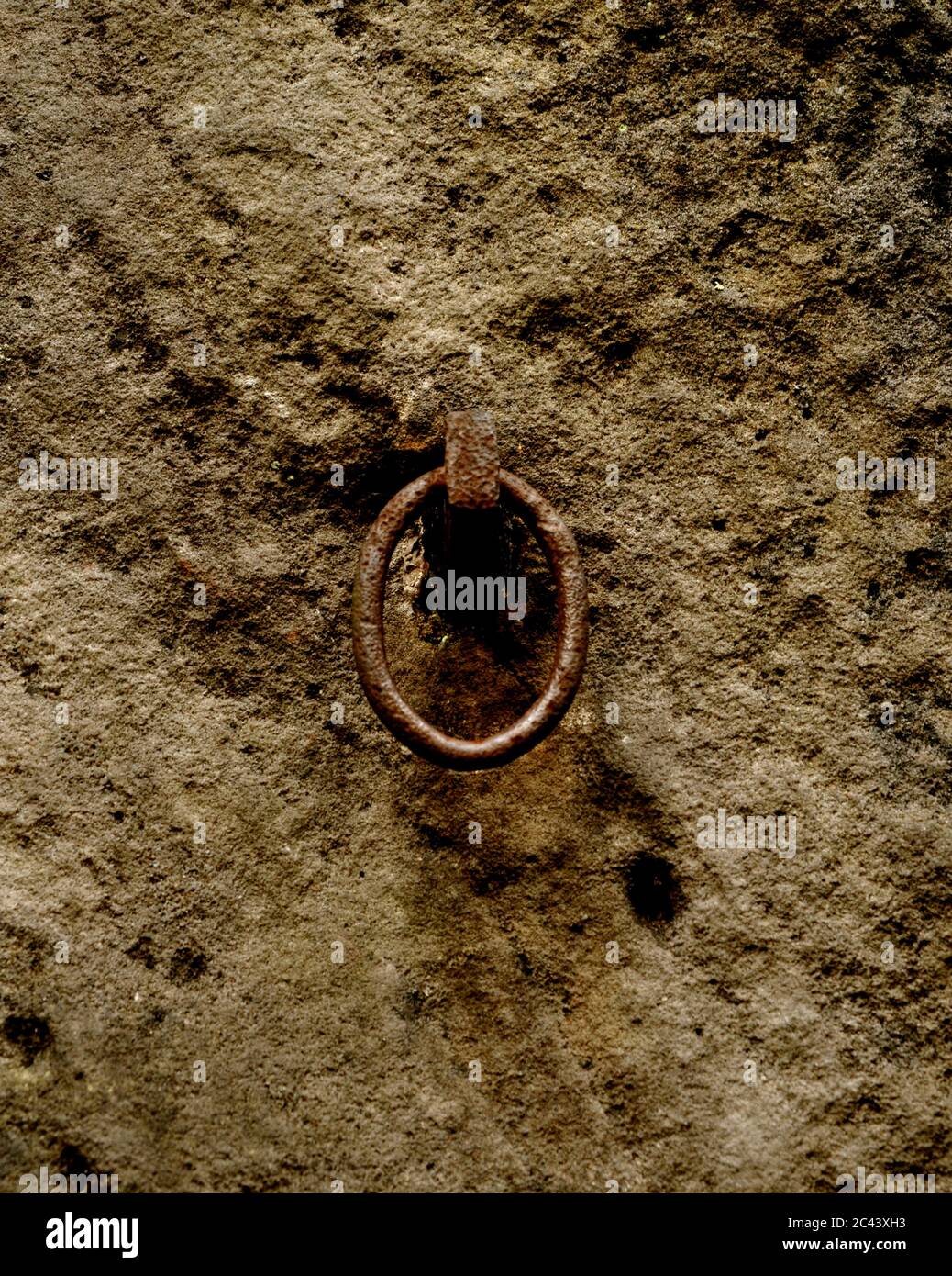 Rusty ring with hooks in a rock face Stock Photo - Alamy