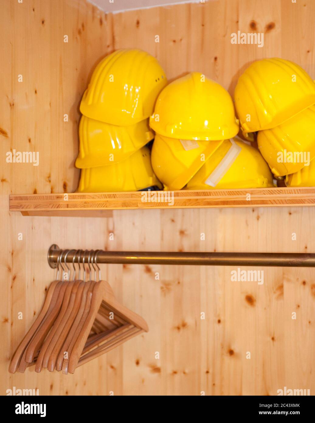Construction helmets and hangers in a closet Stock Photo - Alamy