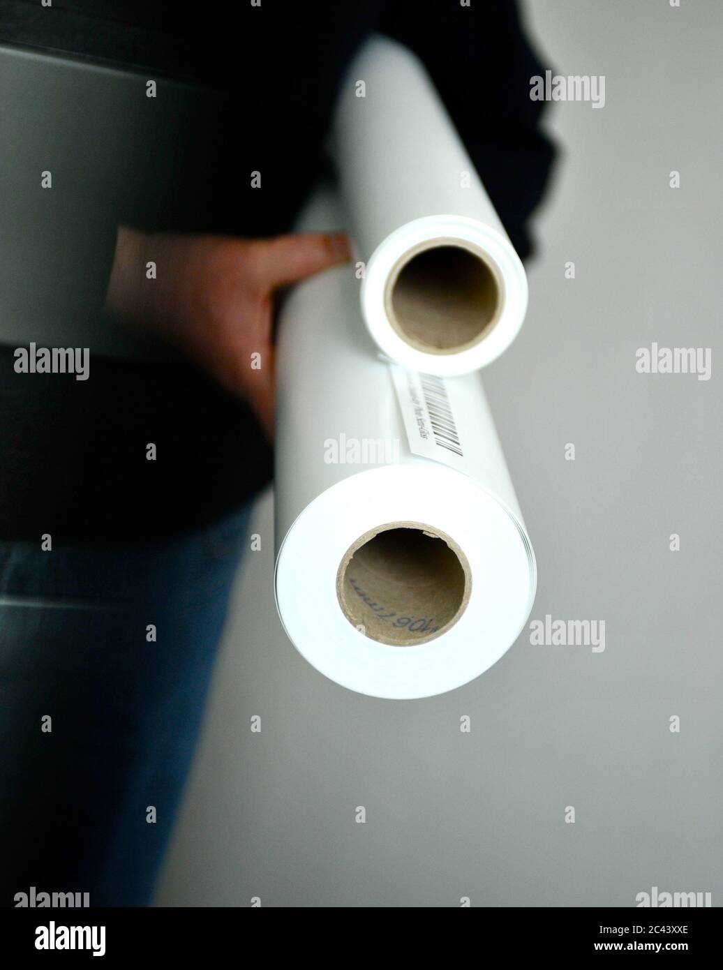 Man carries two rolls of paper Stock Photo - Alamy