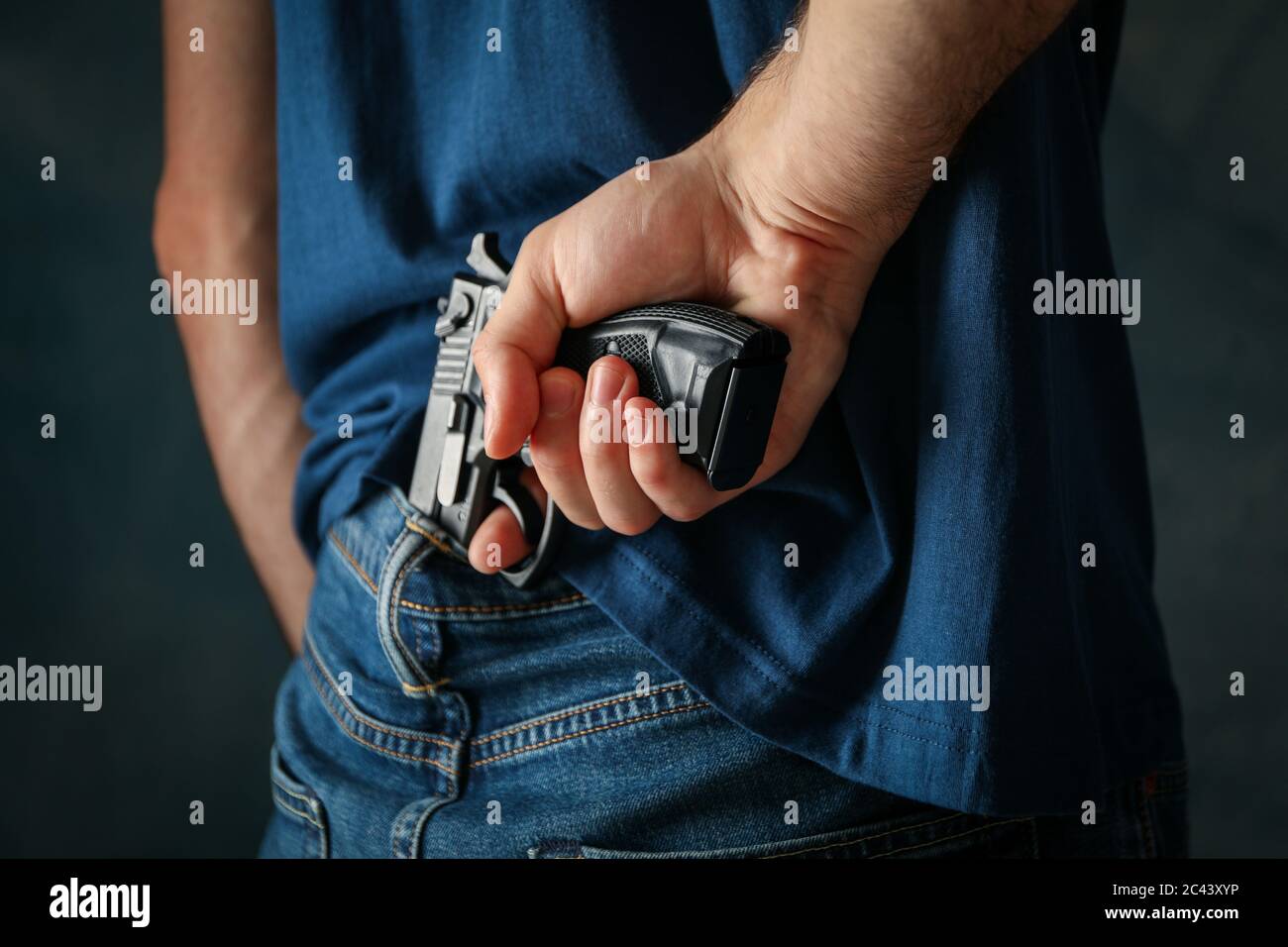 Woman holding gun her hand behind her back hi-res stock photography and ...
