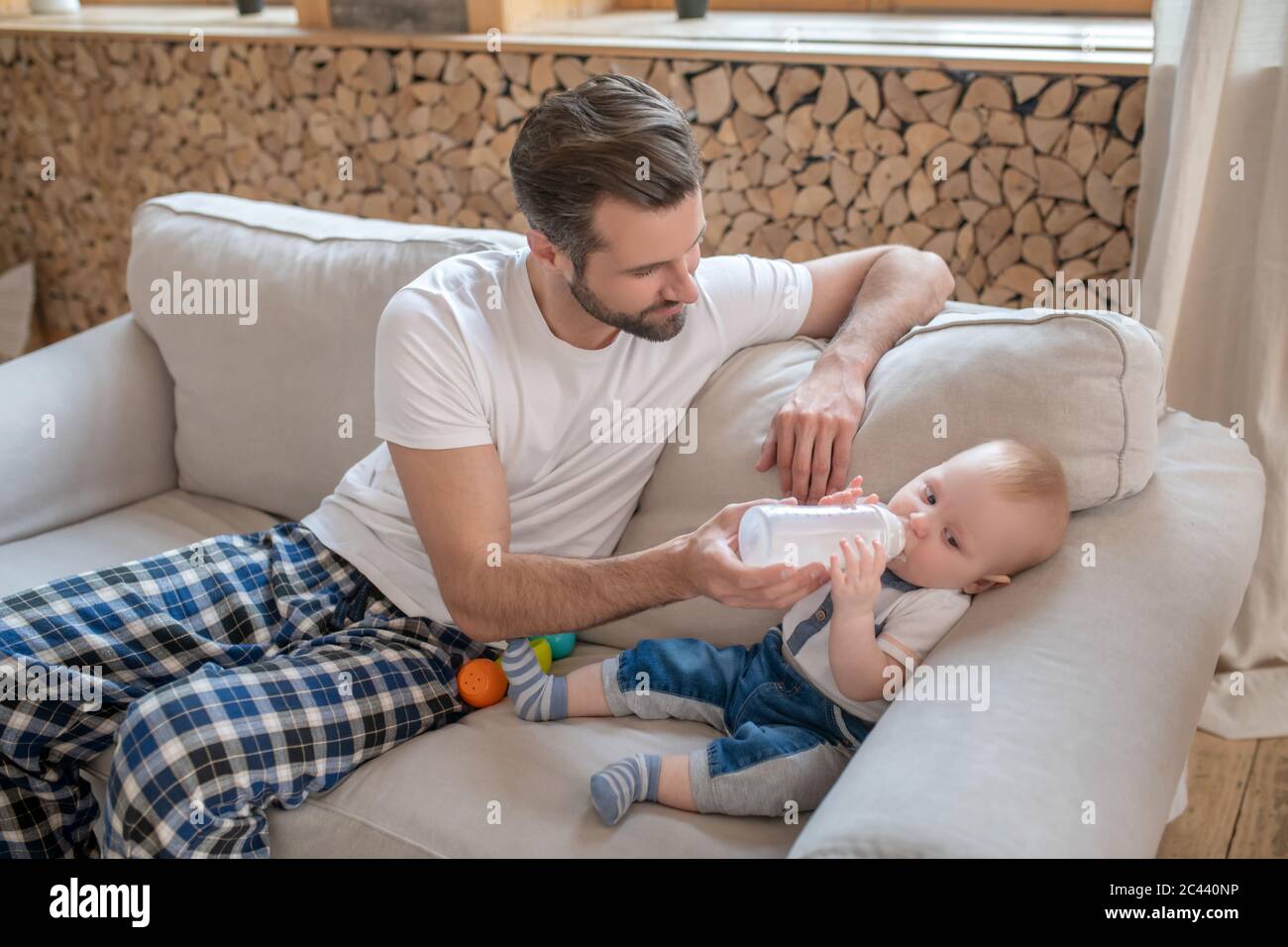 Father feeding the baby from the bottle and feeling happy Stock Photo ...