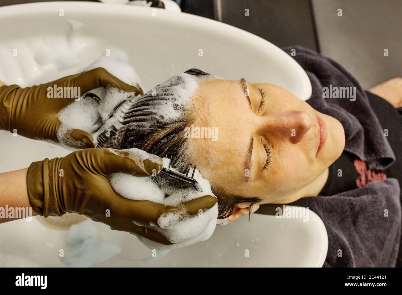 Woman in hair salon getting hair washed with brushes Stock Photo - Alamy