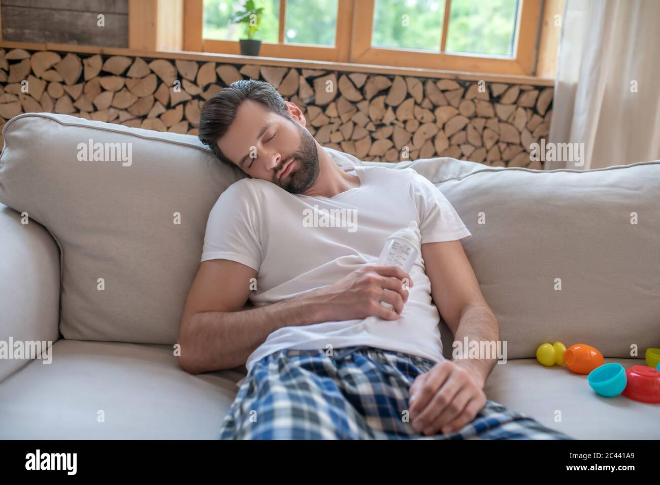 Young happy father napping on the sofa feeling exhausted Stock Photo ...