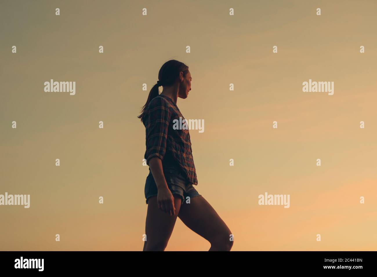 Woman standing on one leg at beach during sunset Stock Photo - Alamy
