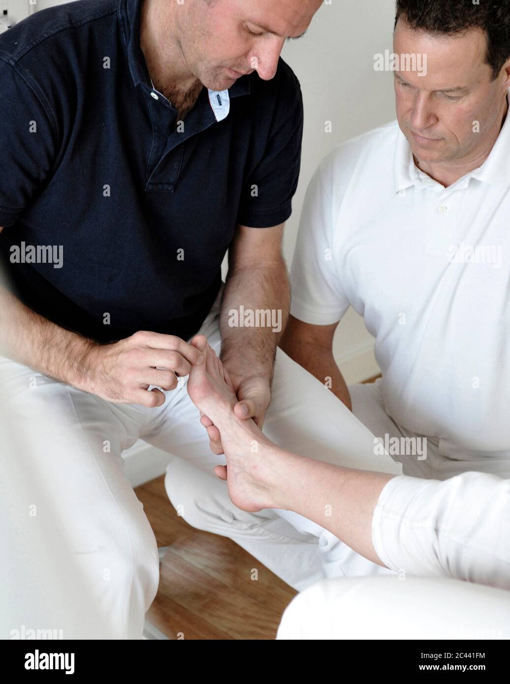 Two doctors treat a patient's foot Stock Photo - Alamy