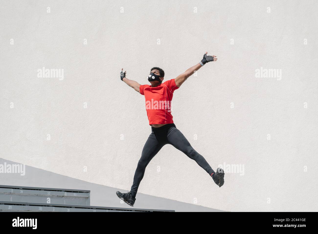 Sportsman wearing face mask jumping on stairs Stock Photo - Alamy