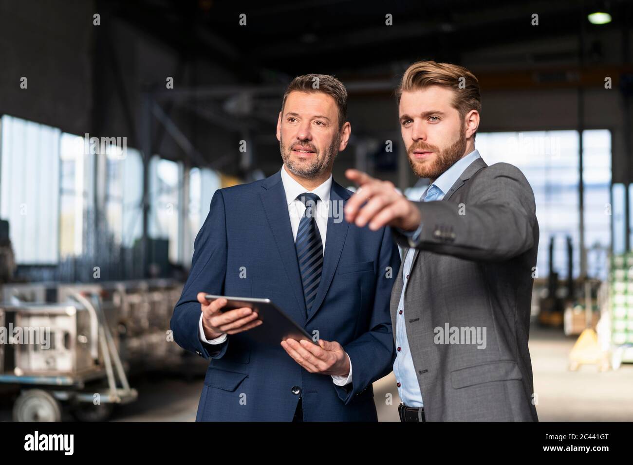 Two businessmen having meeting factory hall hi-res stock photography ...