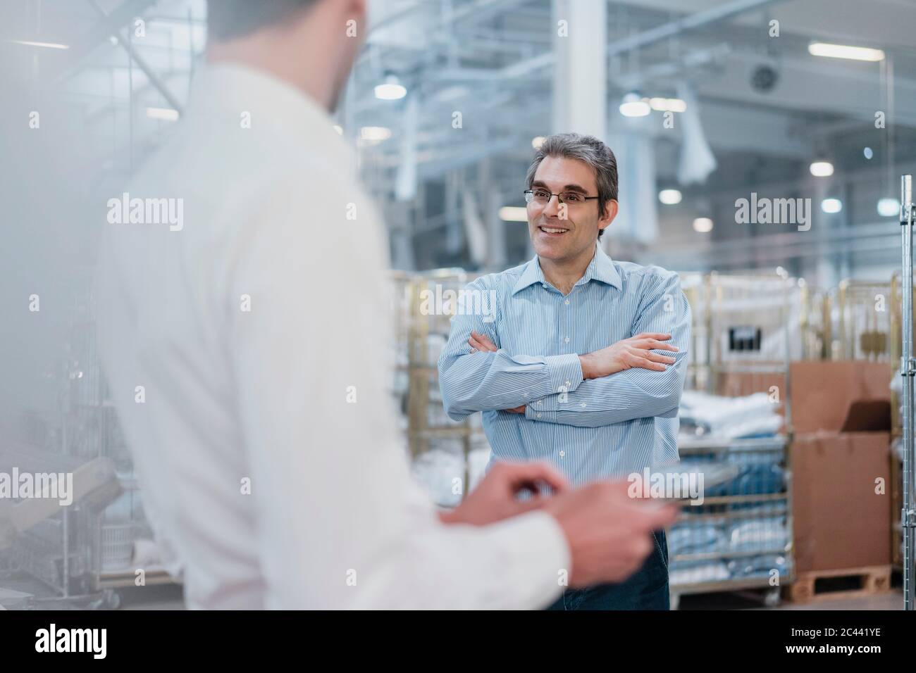Two businessmen having meeting factory hall hi-res stock photography ...