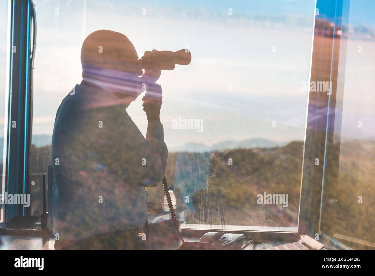 Pilot standing in control tower, using binoculars Stock Photo - Alamy