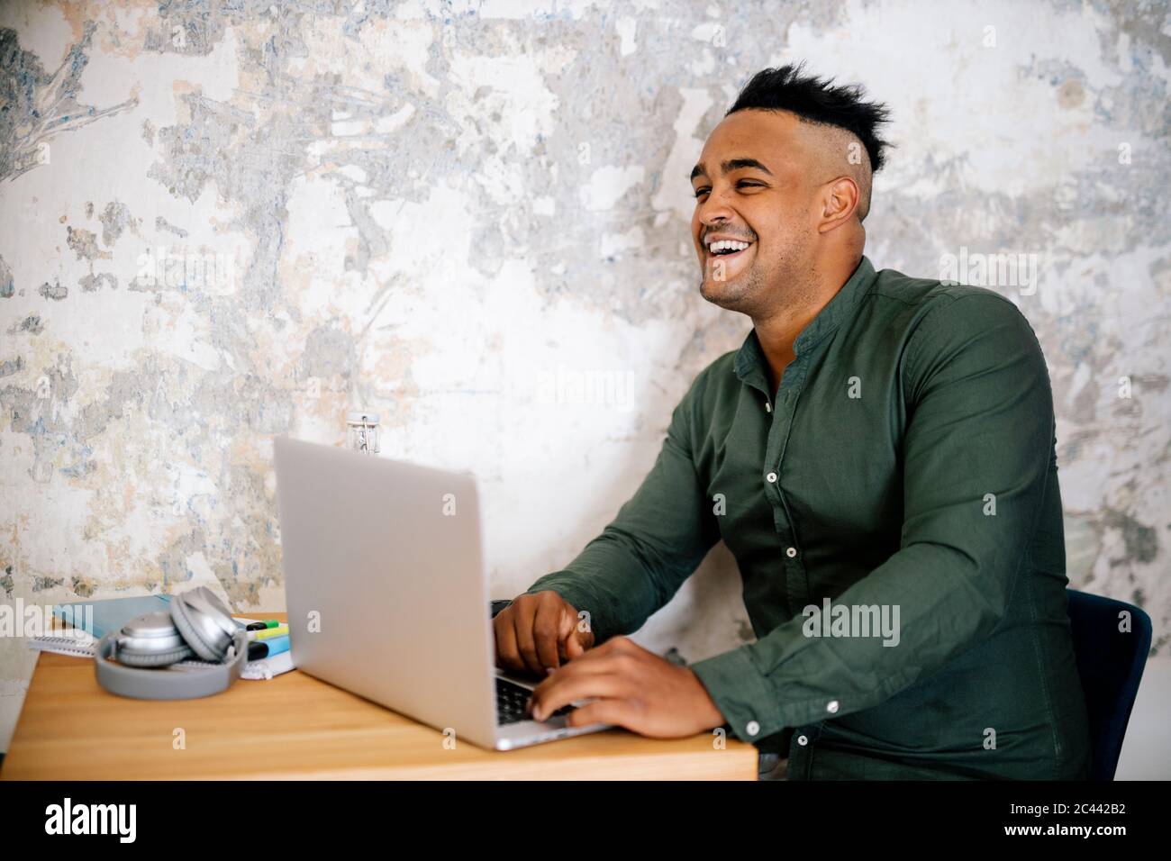 Young man laptop laughing hi-res stock photography and images - Alamy