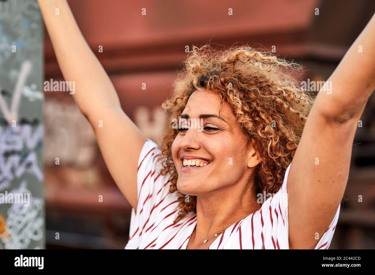 Raising arms smiling hi-res stock photography and images - Alamy
