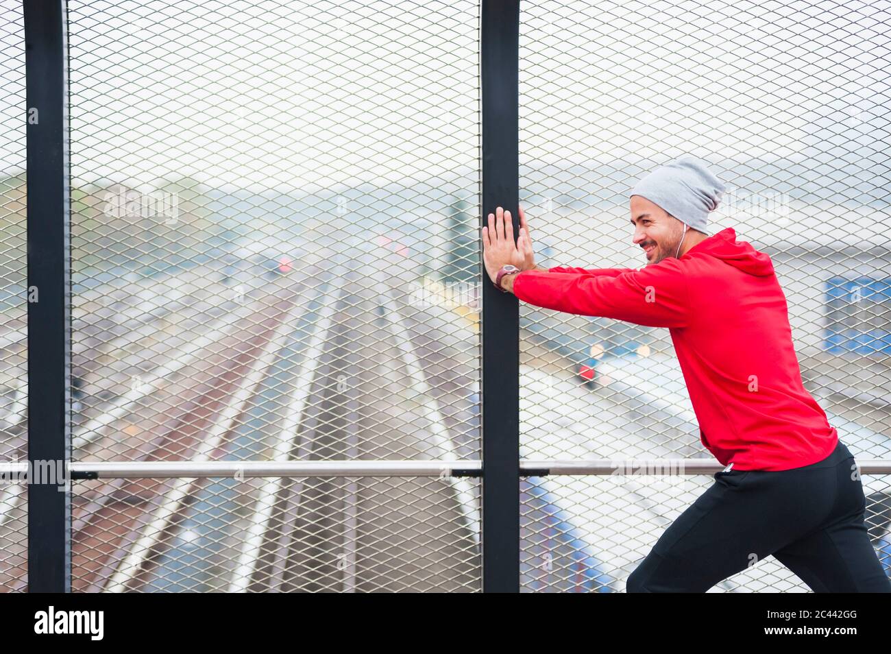 Young man stretching on a railway bridge Stock Photo - Alamy