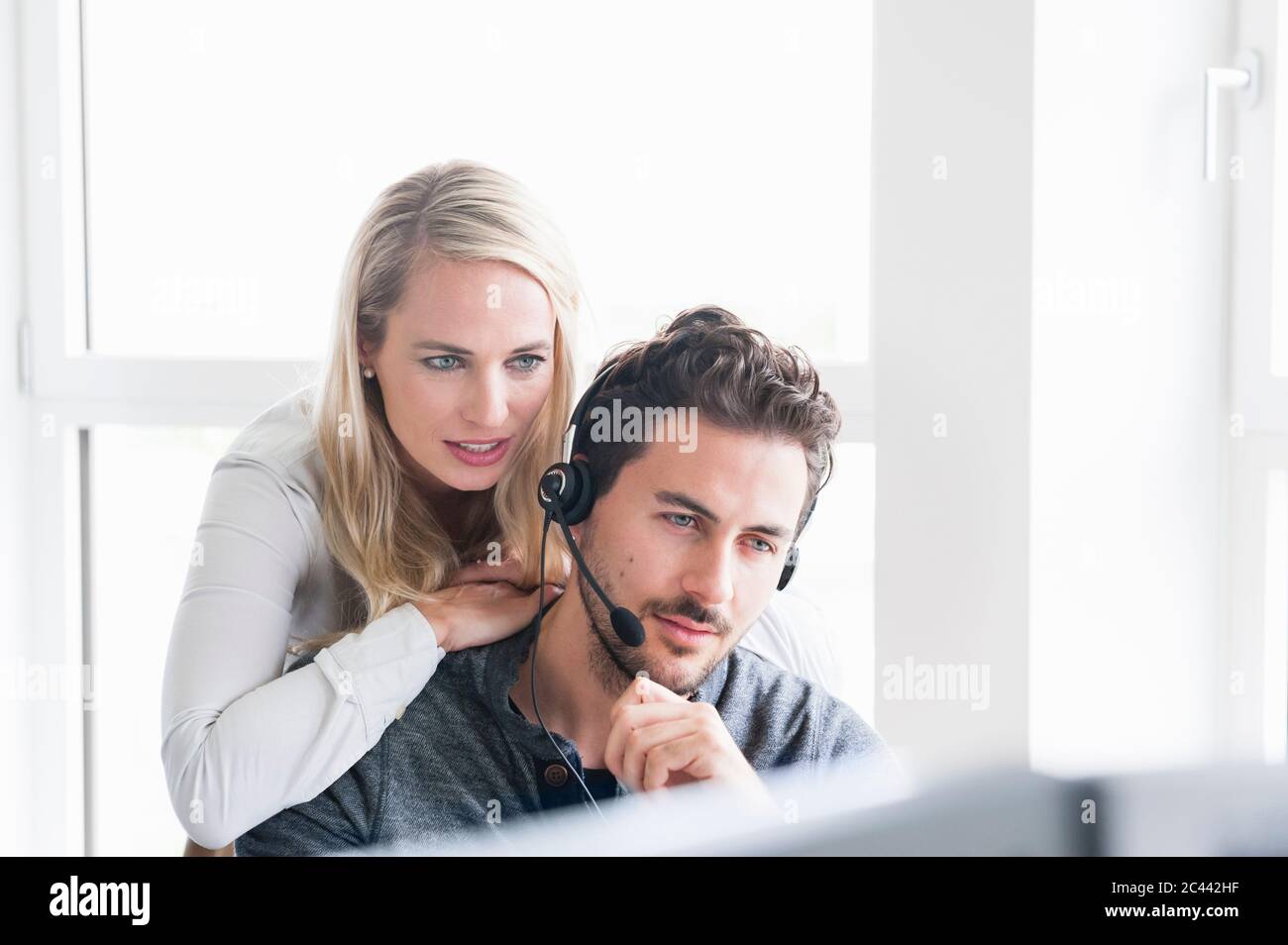 Businesswoman leaning on male customer service representative wearing ...