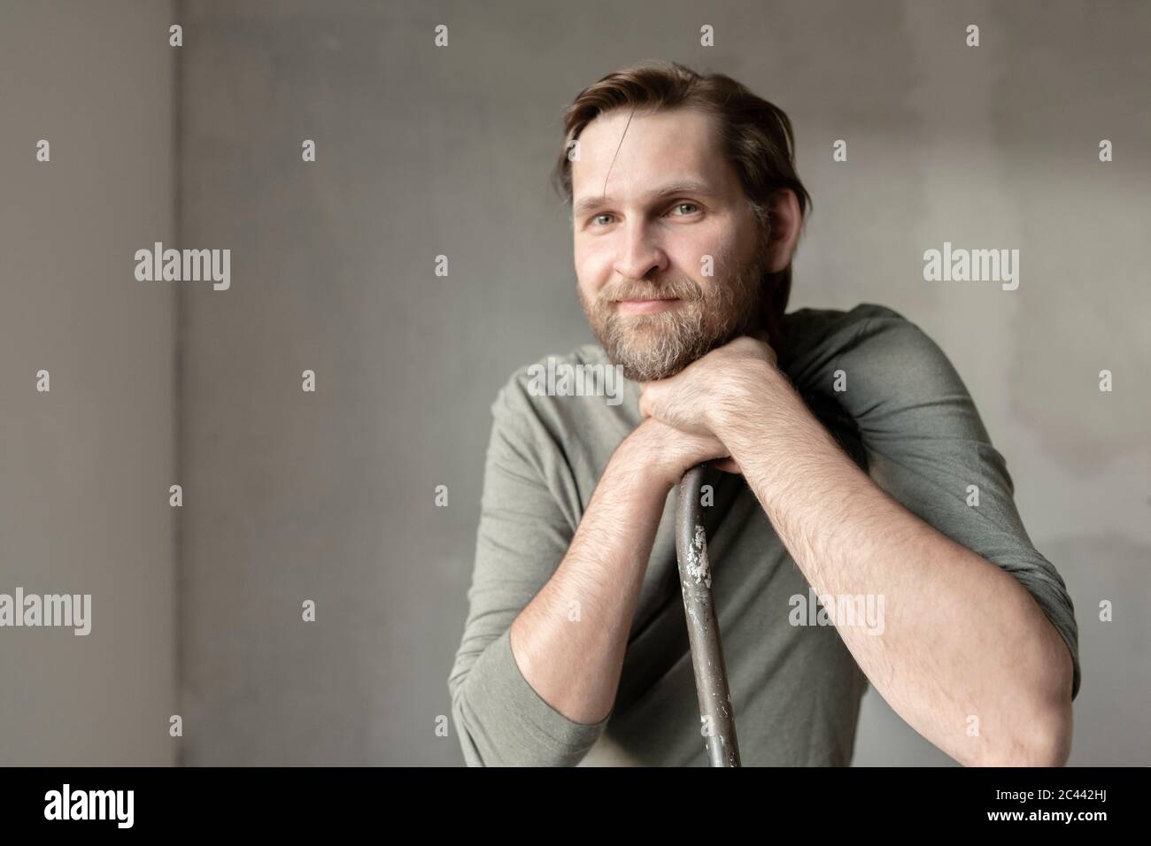 Smiling man leaning on ladder during renovation Stock Photo - Alamy