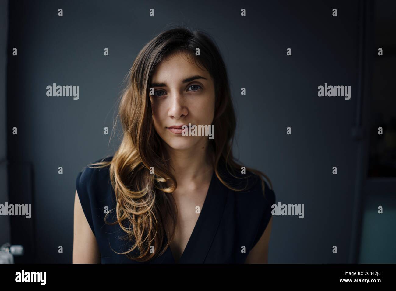 Portrait of serious young woman against grey background Stock Photo - Alamy