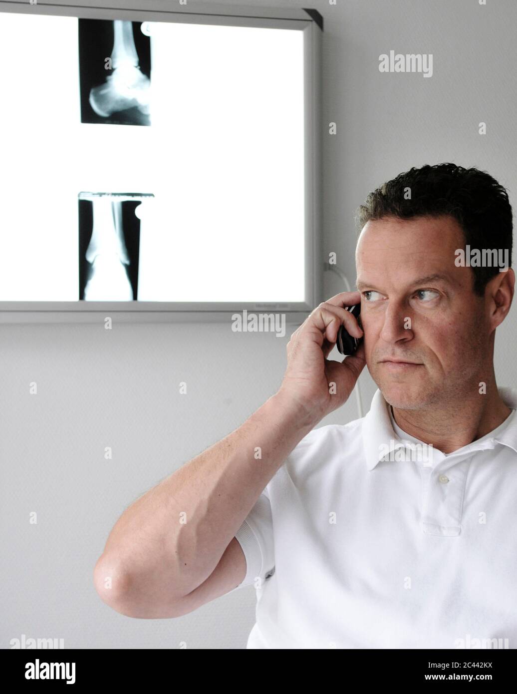 Doctor on the phone in the practice Stock Photo - Alamy
