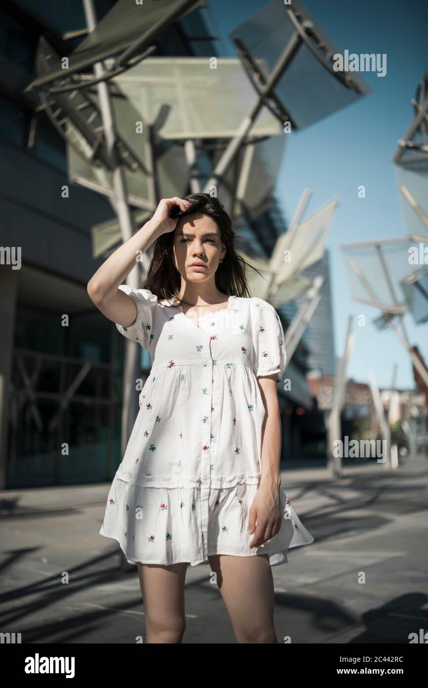 Young woman in mini dress standing on city street Stock Photo - Alamy