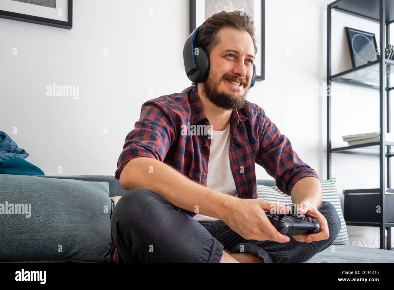 Man sitting on couch and playing video game Stock Photo - Alamy