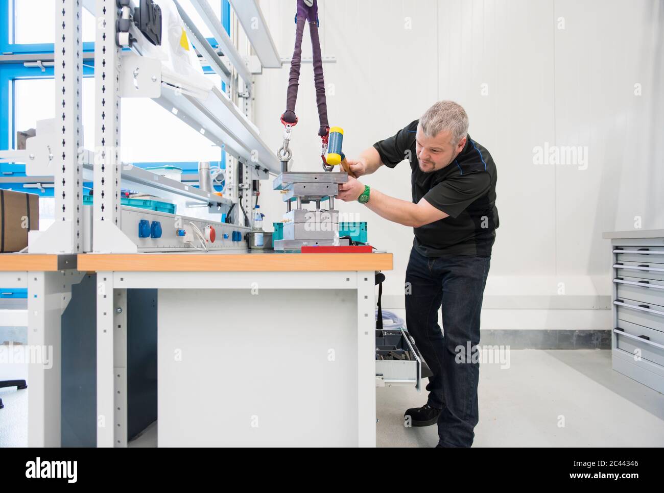 Man working at workbench in a factory Stock Photo - Alamy