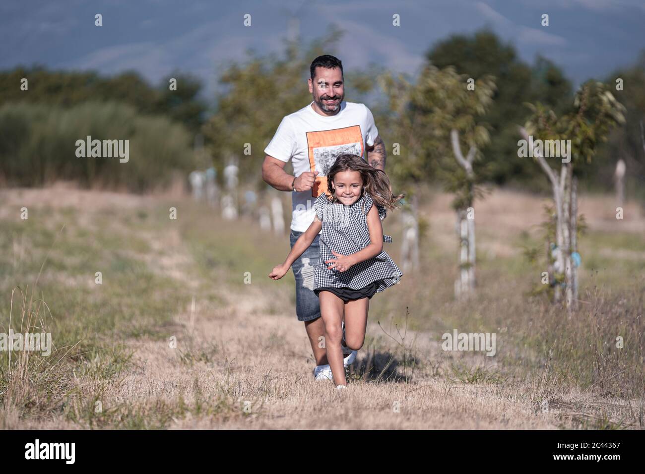 Father running behind his little daughter Stock Photo - Alamy