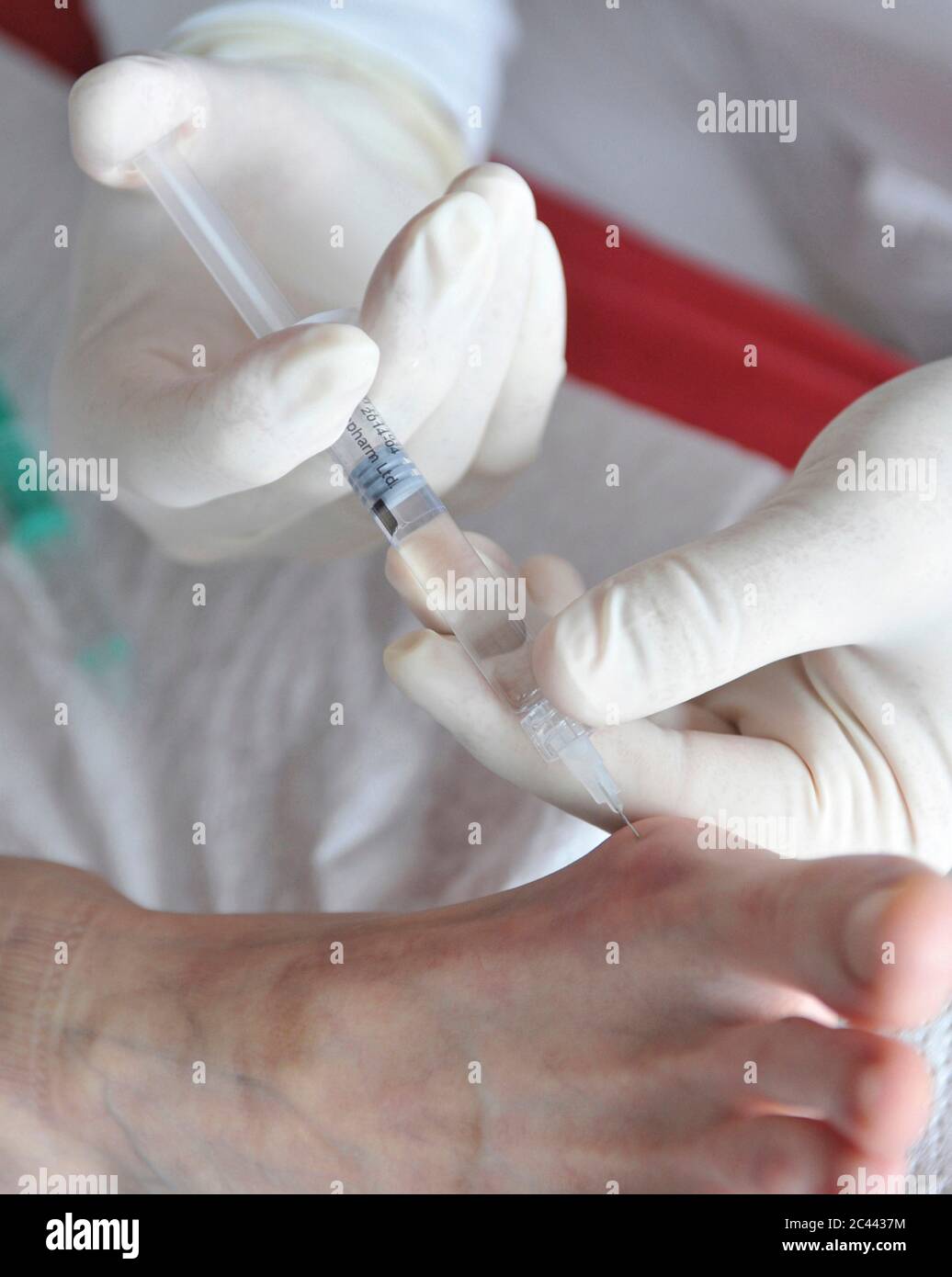 Patient gets an injection in the foot Stock Photo - Alamy