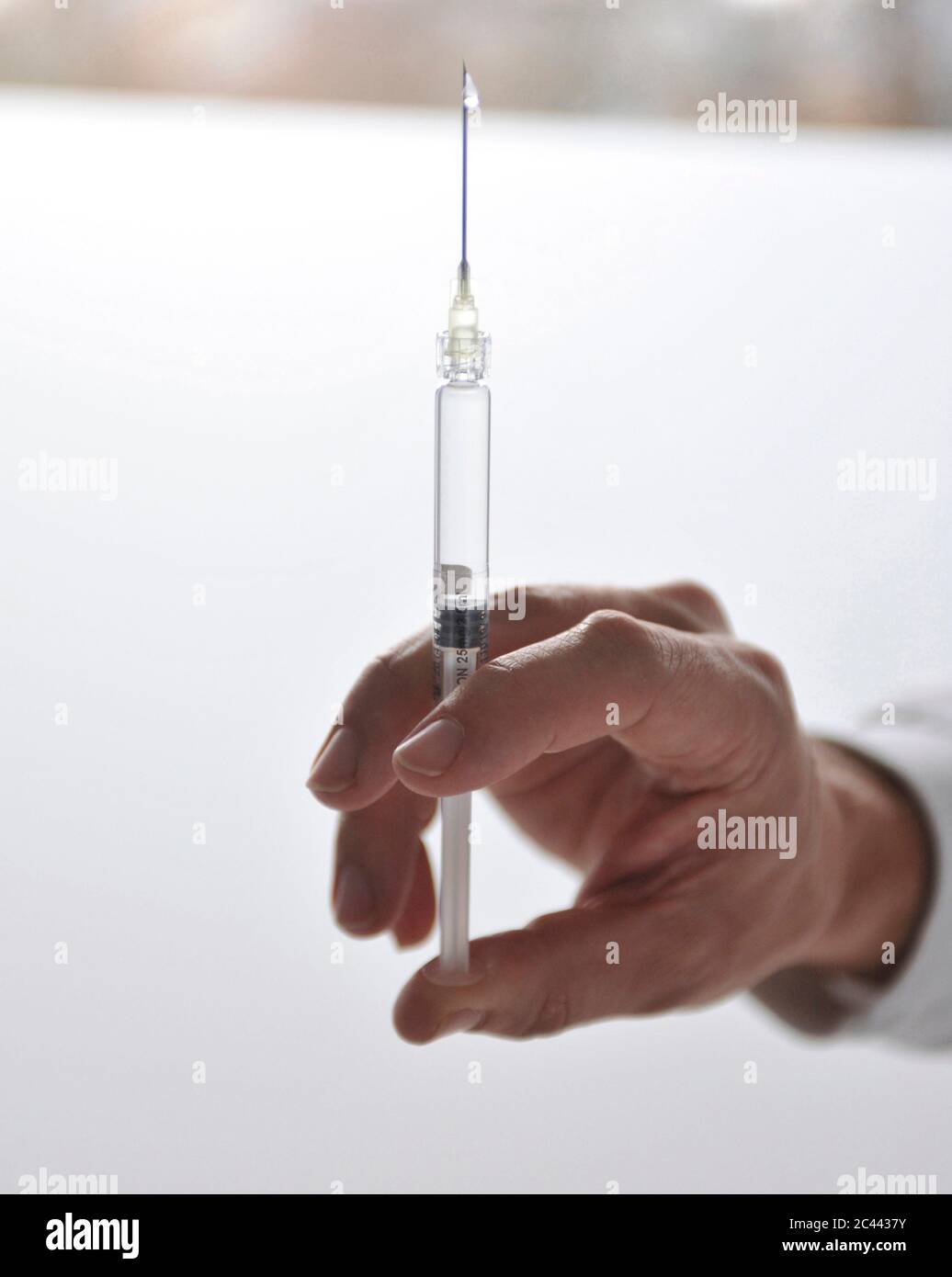 Hand holding a syringe Stock Photo - Alamy