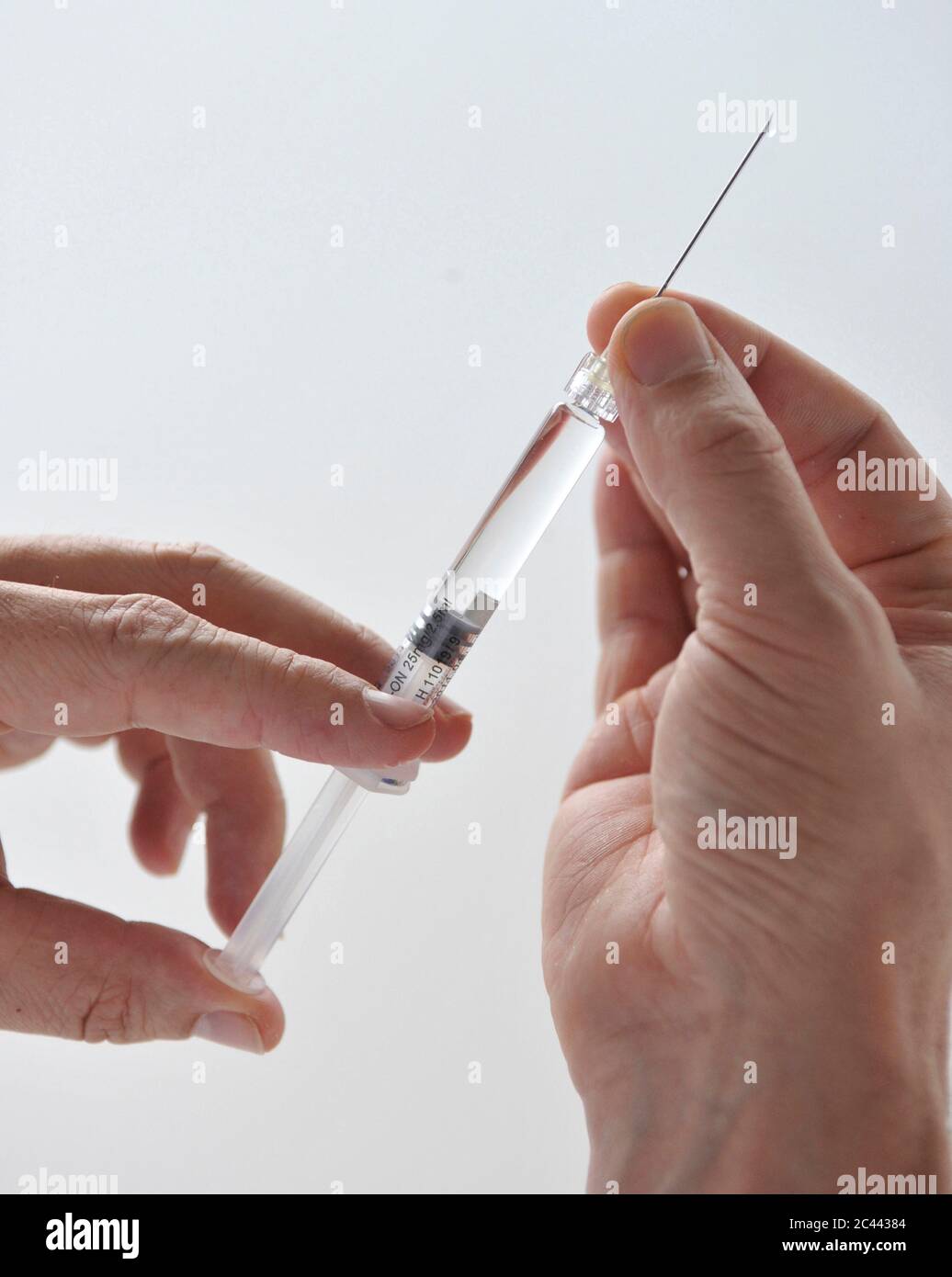 Hand holding a syringe Stock Photo - Alamy