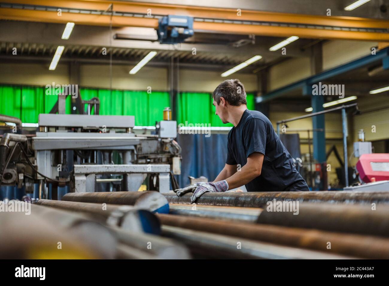 Man working with metal bars in a factory Stock Photo - Alamy