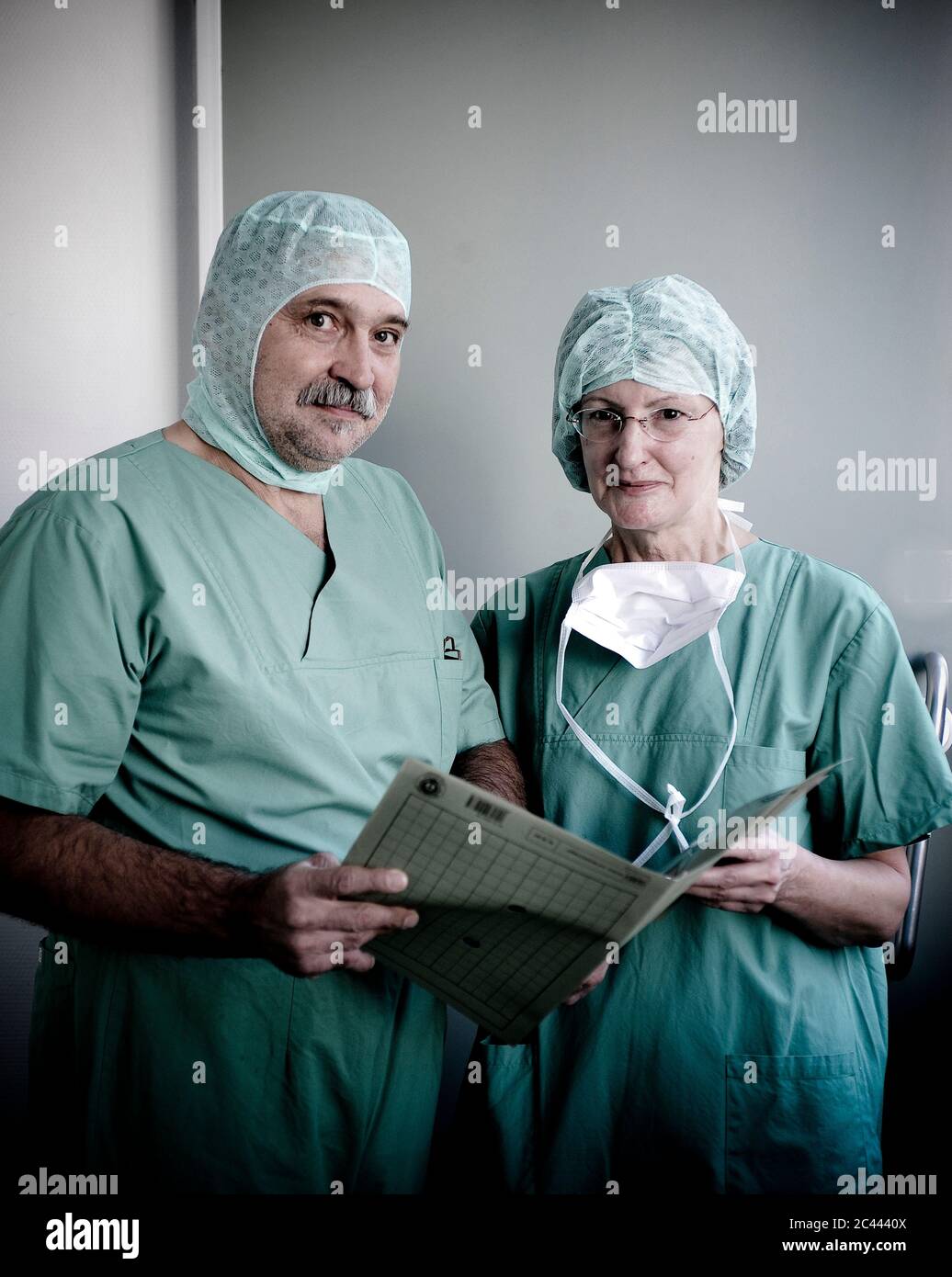 Doctor and nurse in surgical gowns keep a medical record Stock Photo ...