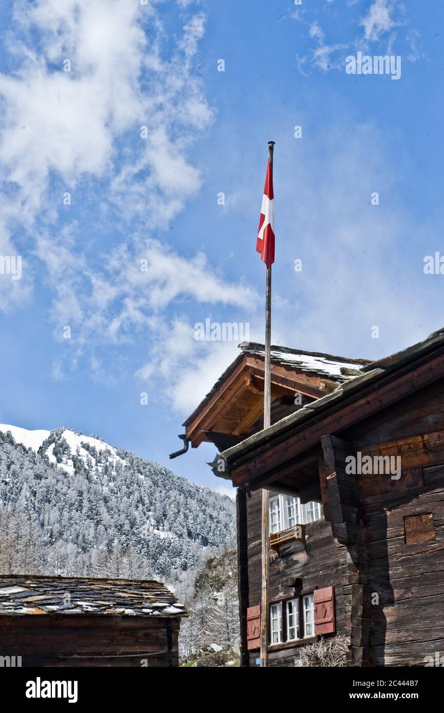 Wooden house with Swiss flag and alpine landscape, Zermatt, Switzerland ...