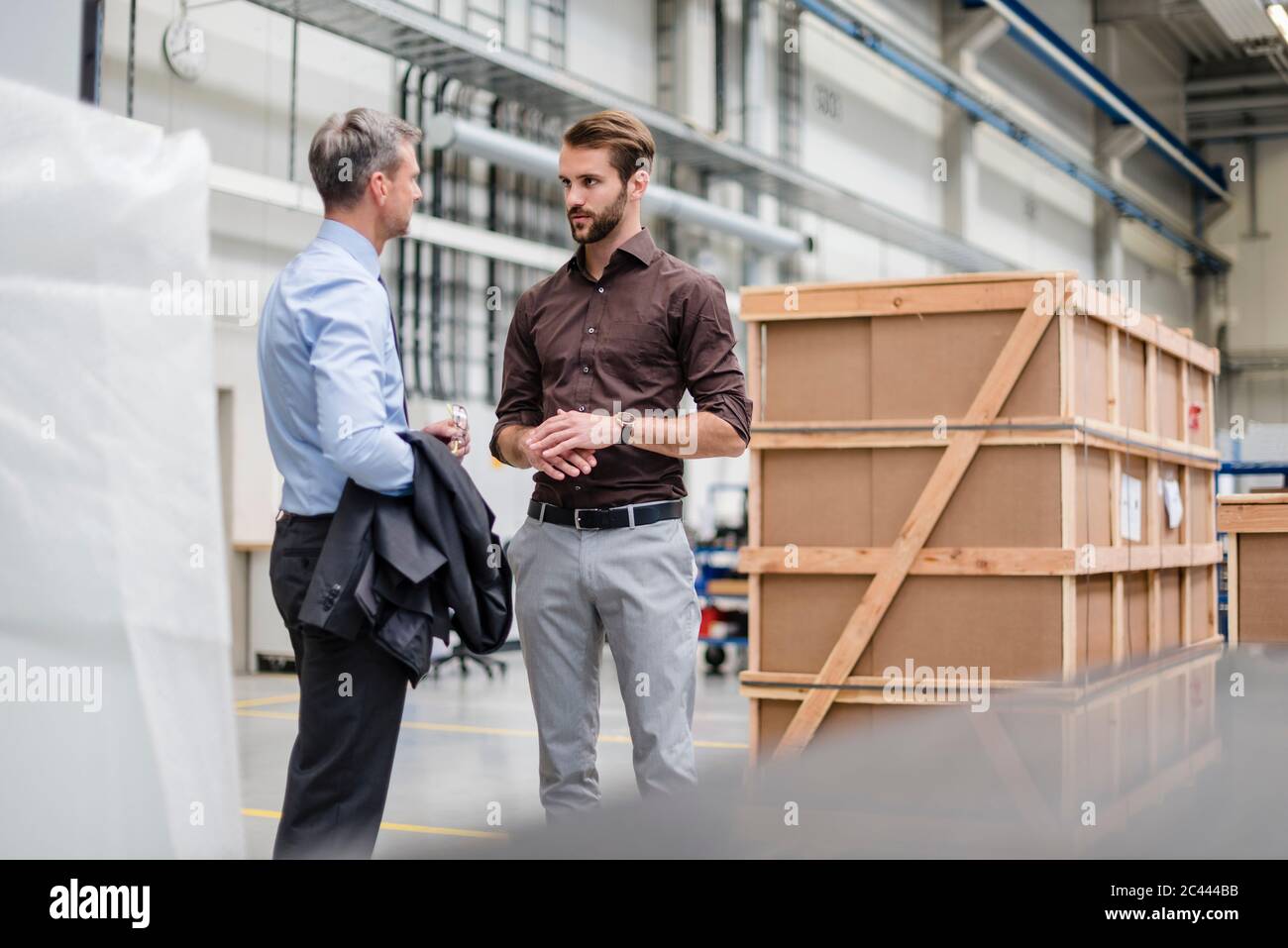 Two businessmen talking in a factory Stock Photo - Alamy