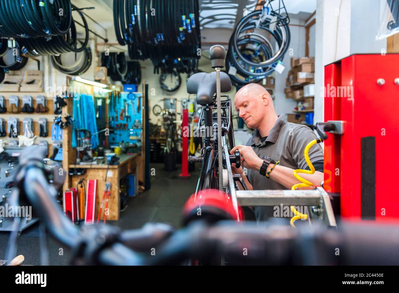 Bicycle mechanic working in bike shop Stock Photo - Alamy